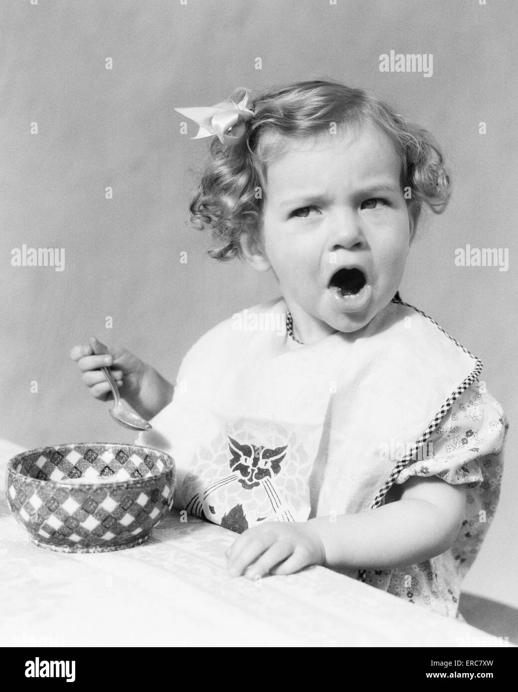 1930s GIRL EATING IN HIGHCHAIR MAKING FUNNY FACE MOUTH OPEN Stock Photo ...