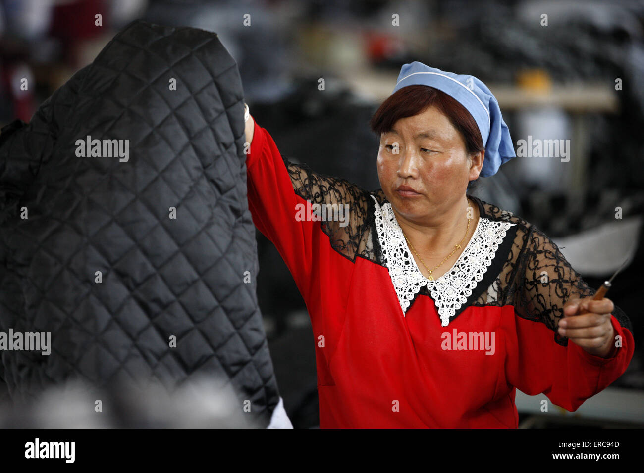Chinese famle labors work at a cloth factory in Huaibei, Anhui province ...