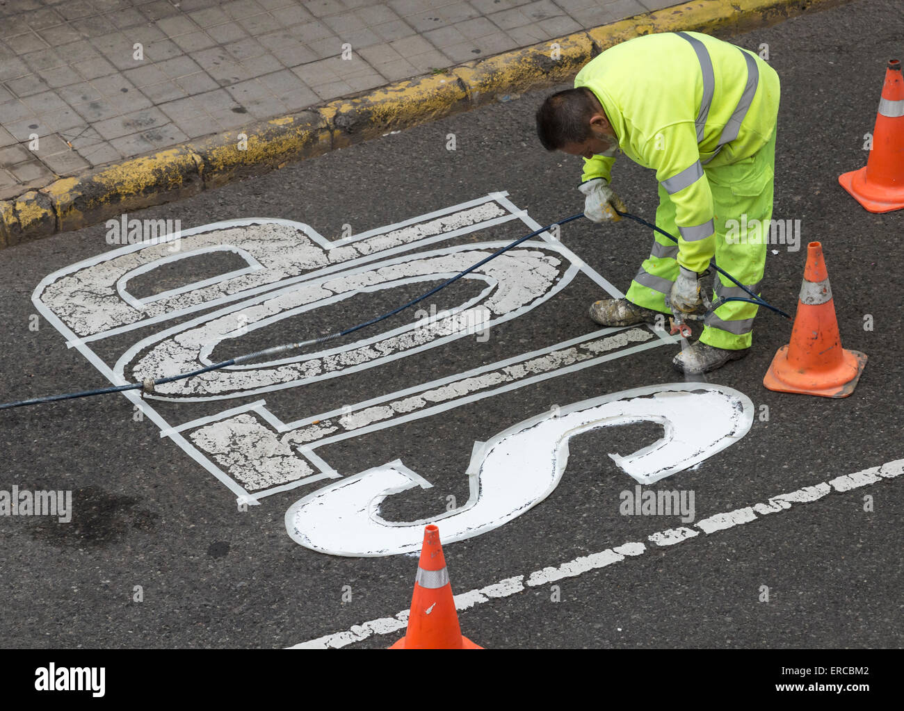 Workman repainting Stop sign on road Stock Photo - Alamy