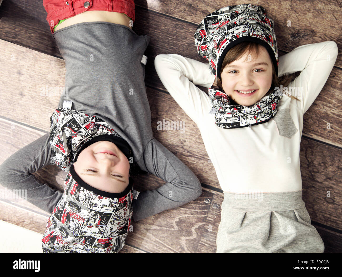 Cheerful kids lying on the wooden floor Stock Photo - Alamy