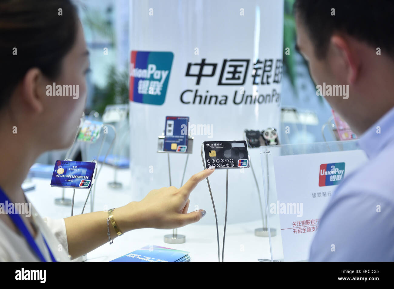 Beijing, China. 1st June, 2015. A staff member (L) of China UnionPay ...