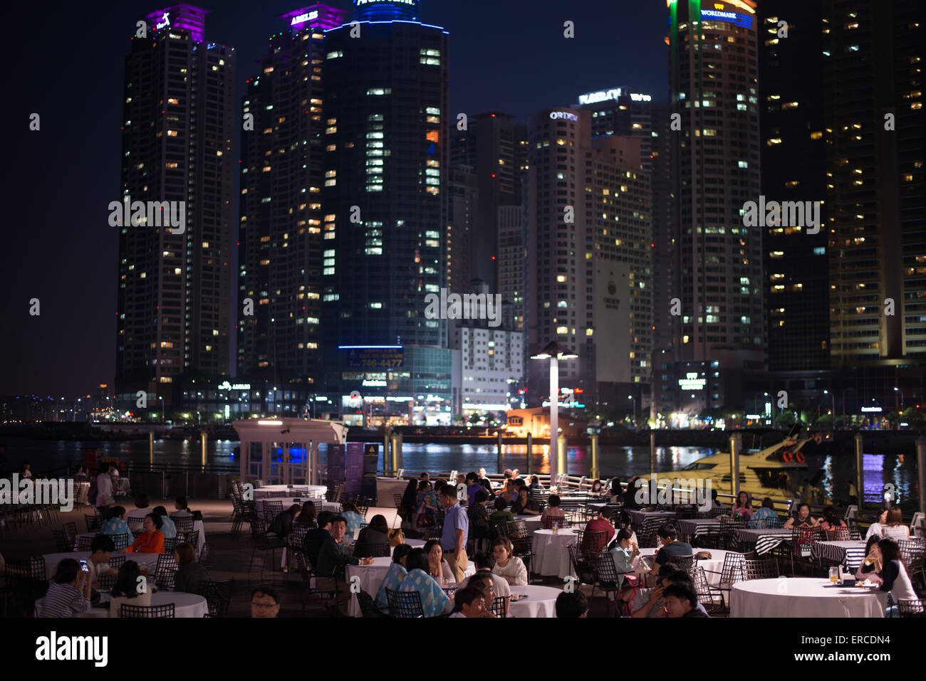 Nightlife in Busan, people eating and drinking along waterside with ...