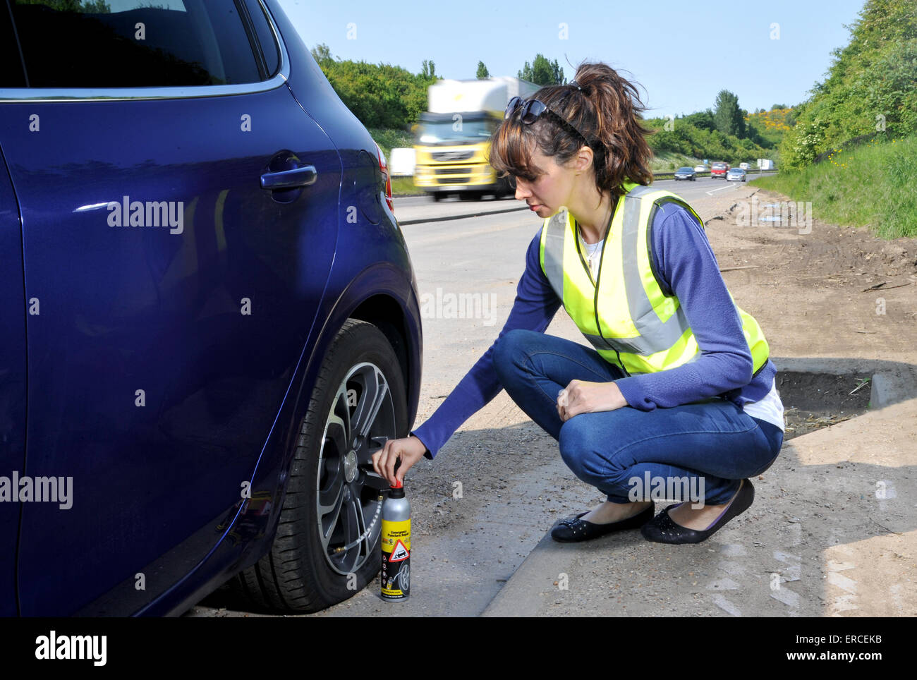 Woman with car puncture using a can of tyre sealant and inflater Stock ...