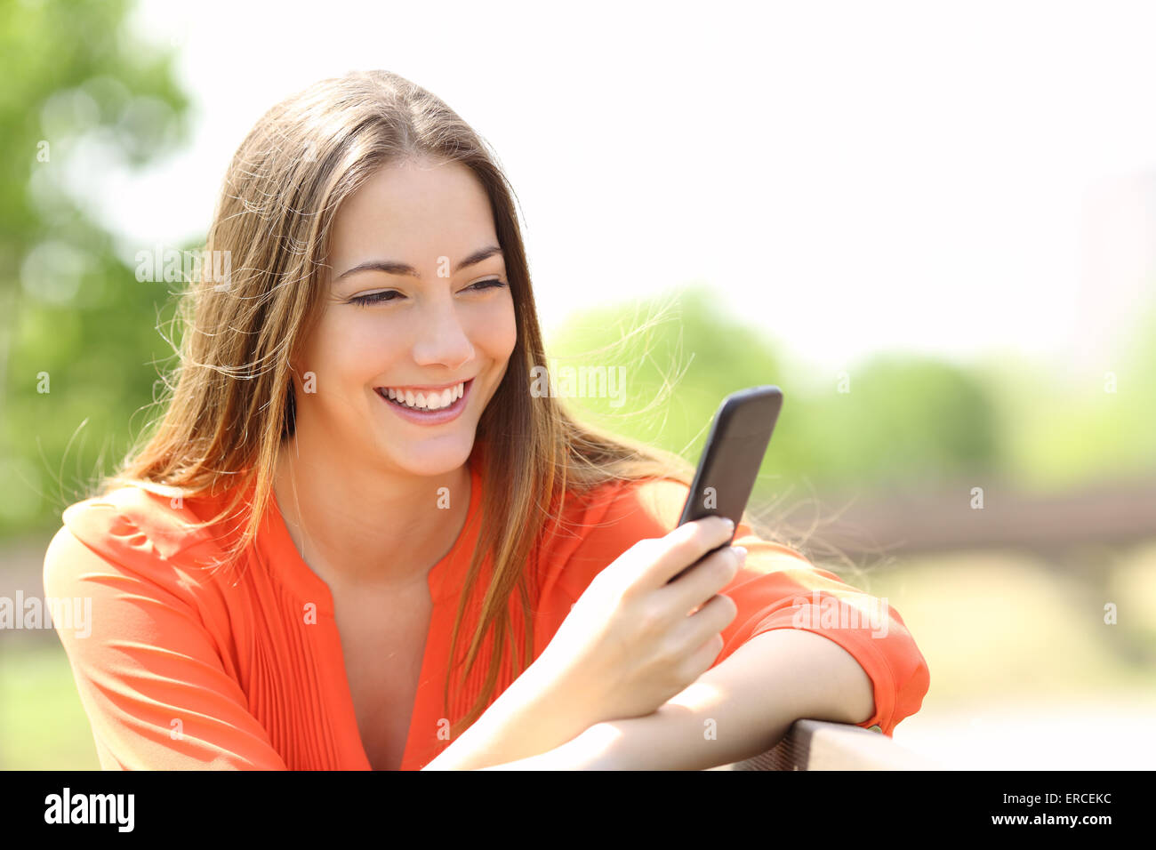Happy girl using a smart phone in summer in a park Stock Photo - Alamy