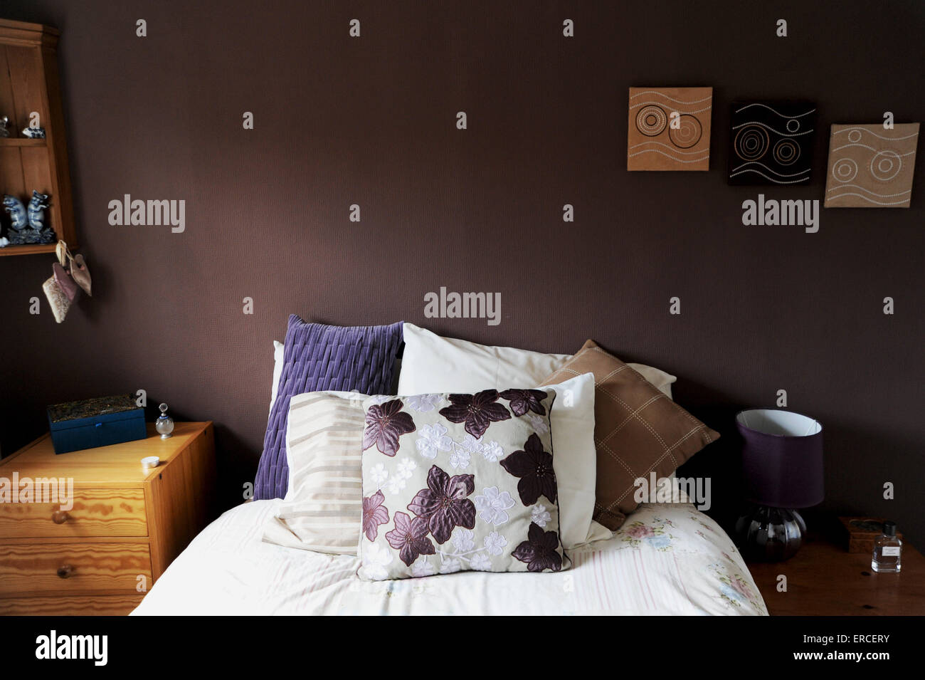 Bedroom furniture with cushions scattered on bed Stock Photo - Alamy