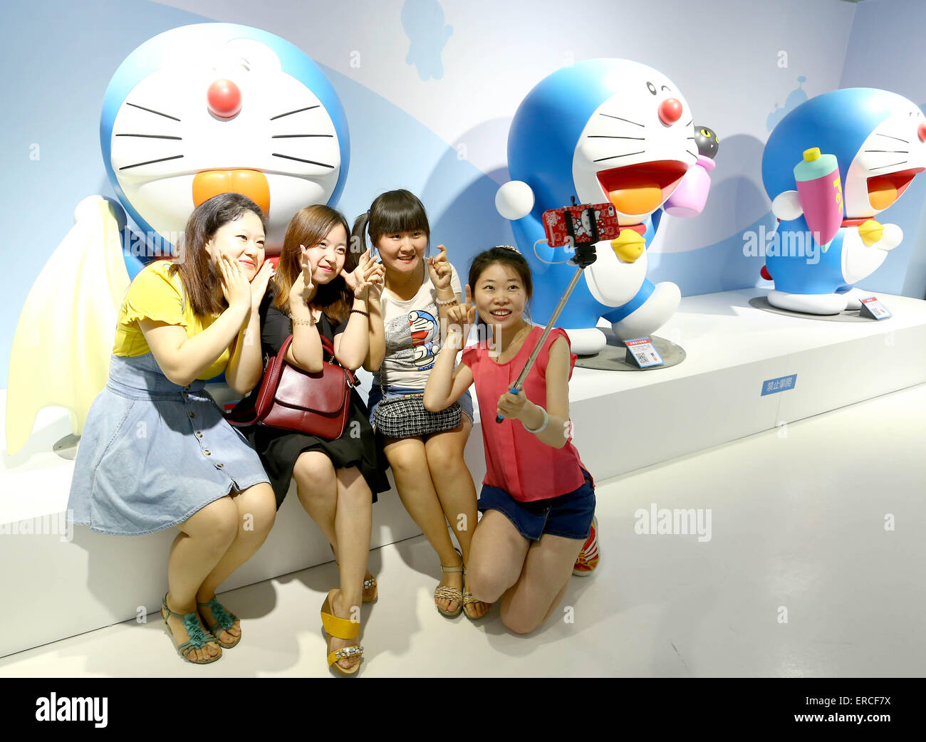 Beijing, China. 1st June, 2015. Girls take selfies with figures of ...