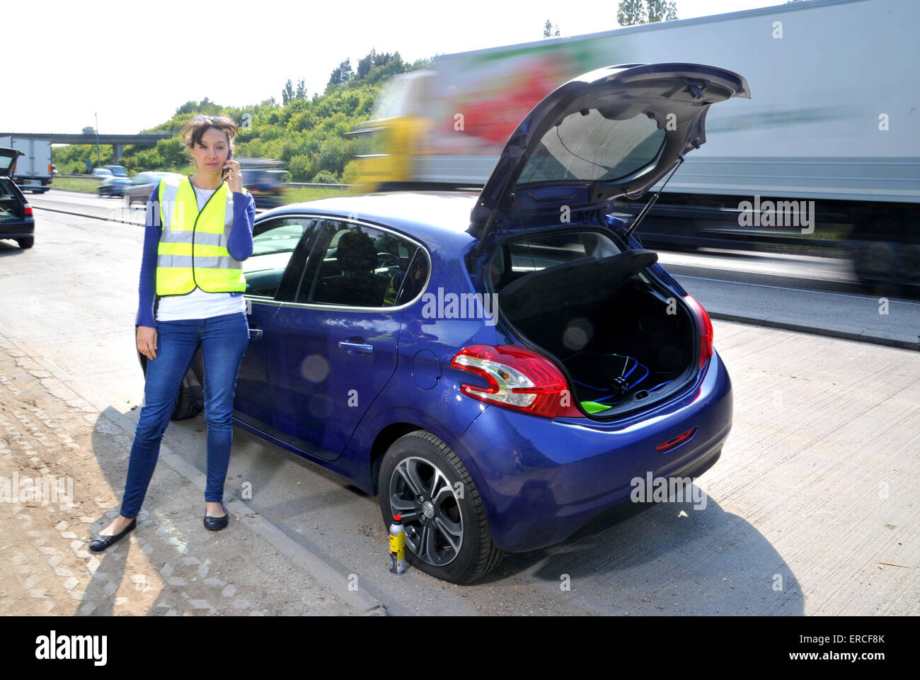 Woman with car puncture using a can of tyre sealant and inflater Stock ...