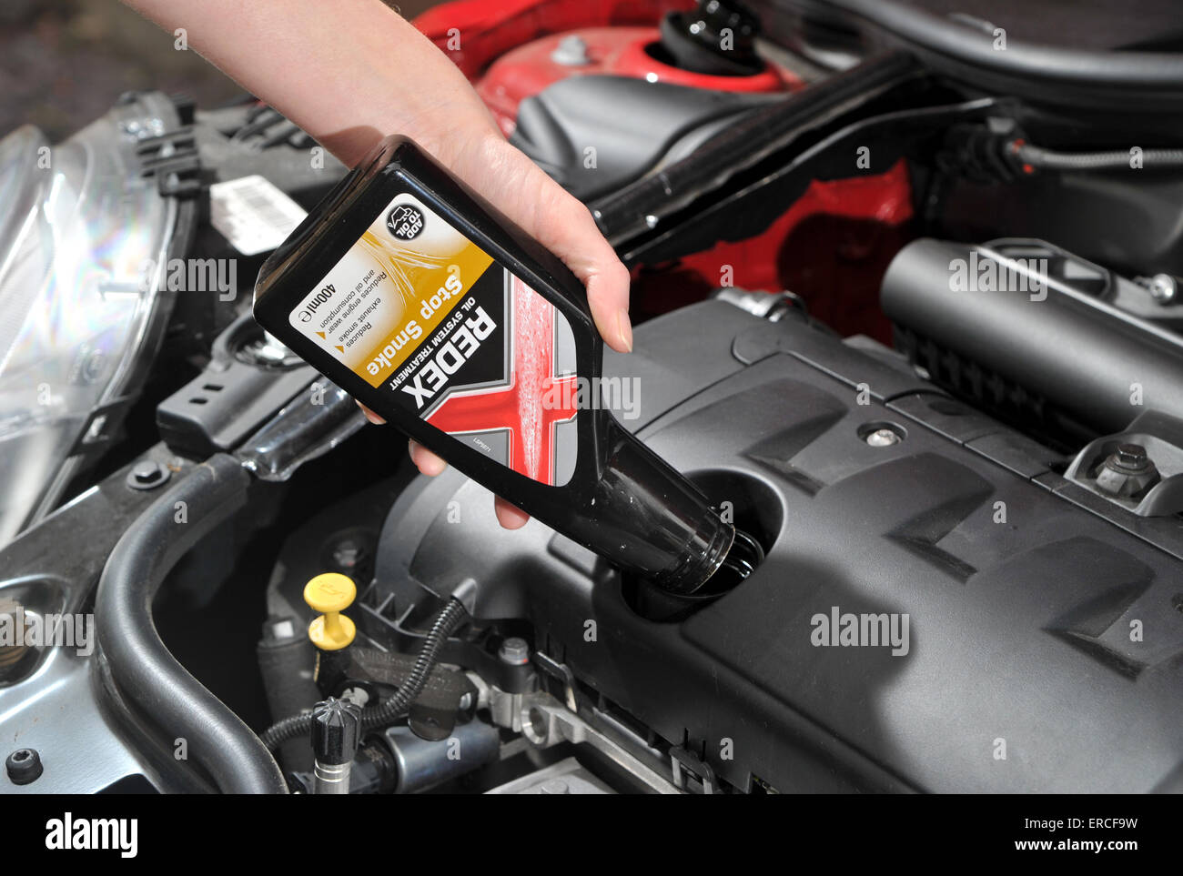Pouring an oil additive into a car engine to stop it from smoking Stock ...