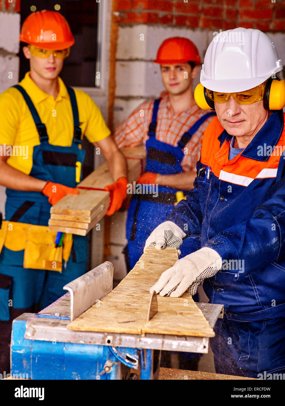Group people builder with circular saw Stock Photo - Alamy