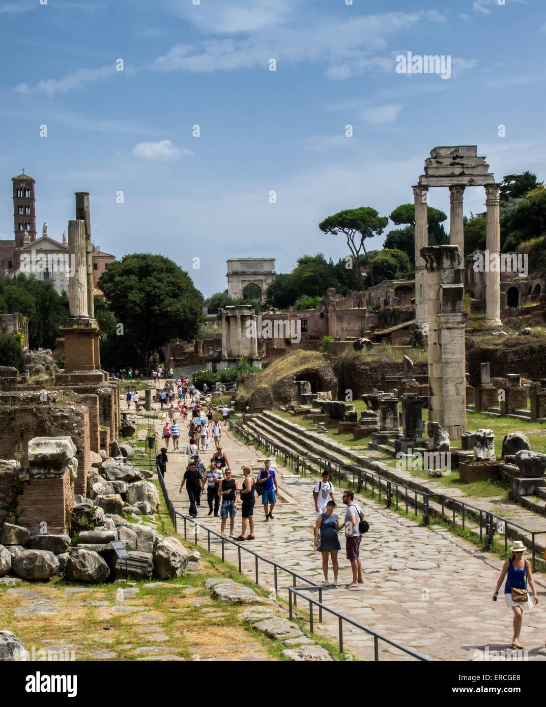 Tourists walk down the middle of the Roman Forum, on the Via Sacra, the ...