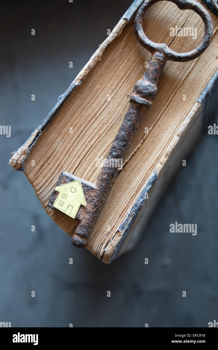 Key of house. Vintage key, old book and paper house Stock Photo - Alamy