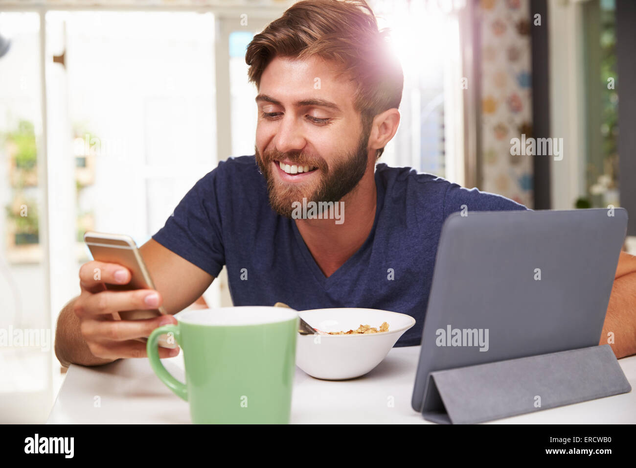 Man Eating Breakfast Whilst Using Digital Tablet And Phone Stock Photo ...