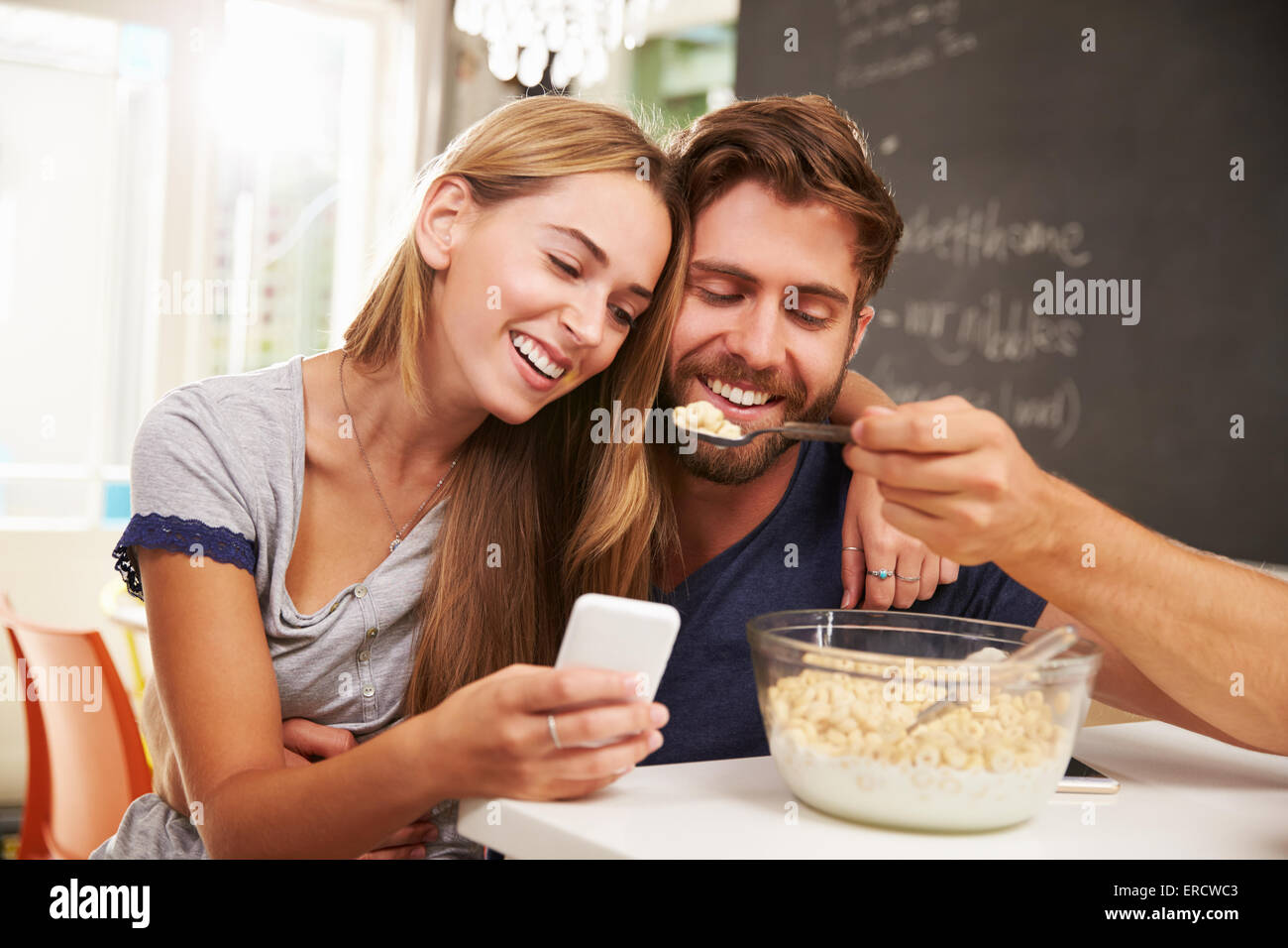 Young Couple Eating Breakfast Whilst Using Mobile Phones Stock Photo ...