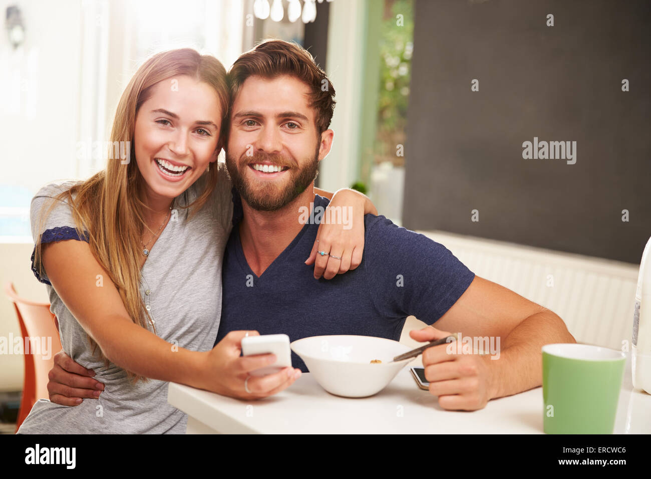 Young Couple Eating Breakfast Whilst Using Mobile Phones Stock Photo ...