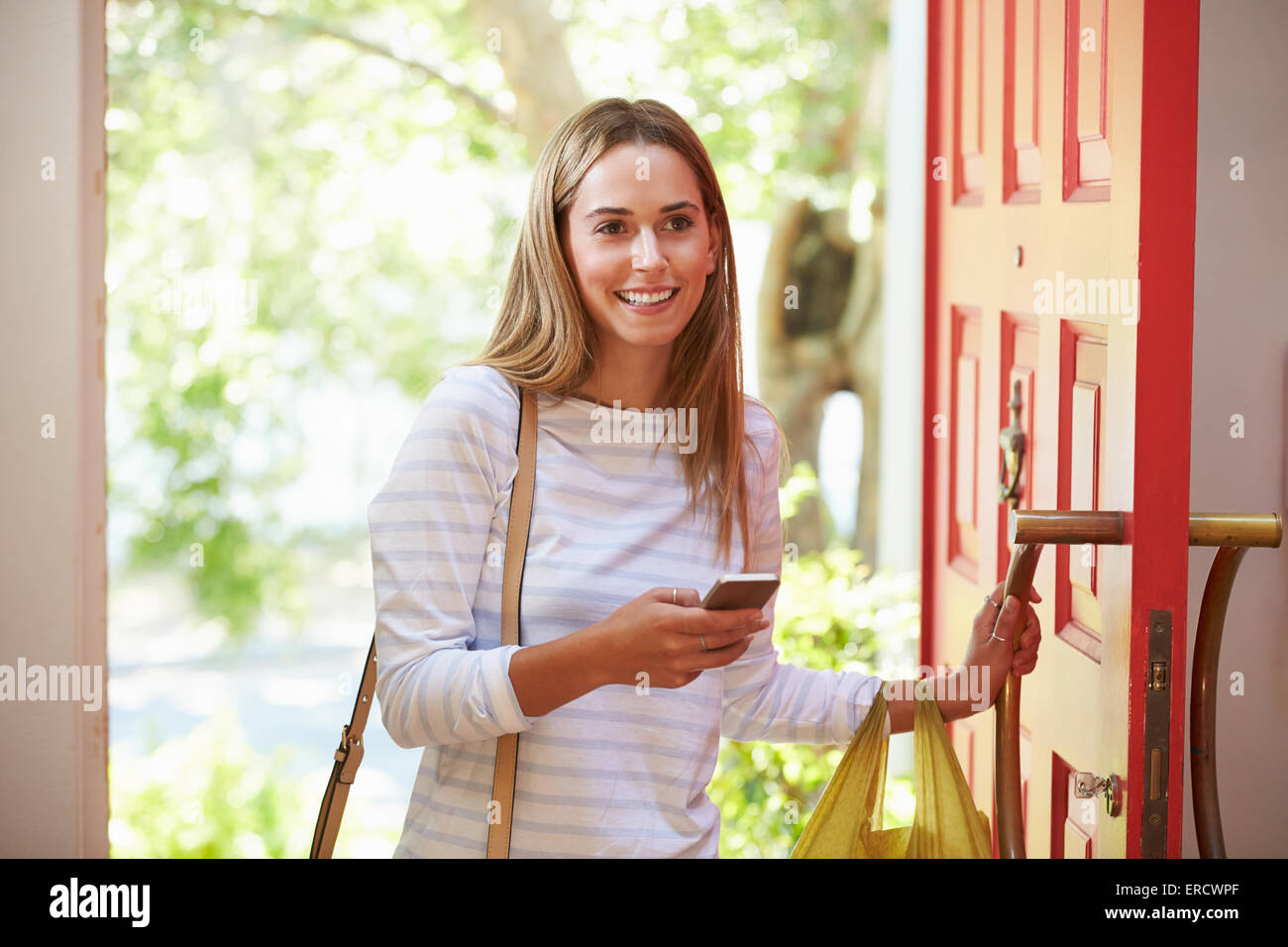 Young Woman Returning Home For Work With Shopping Stock Photo - Alamy