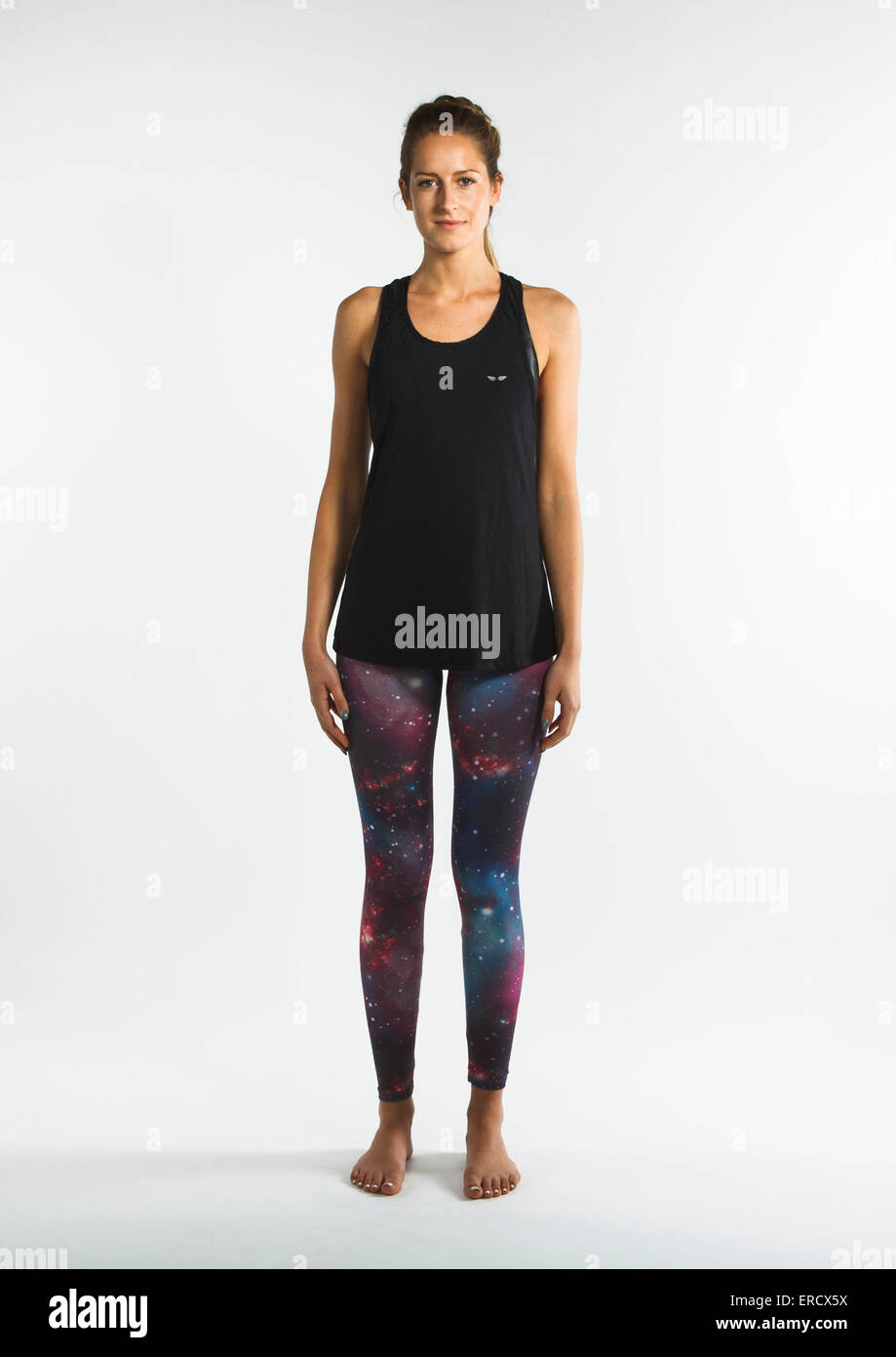 Young woman stood against white backdrop modeling sportswear clothes ...