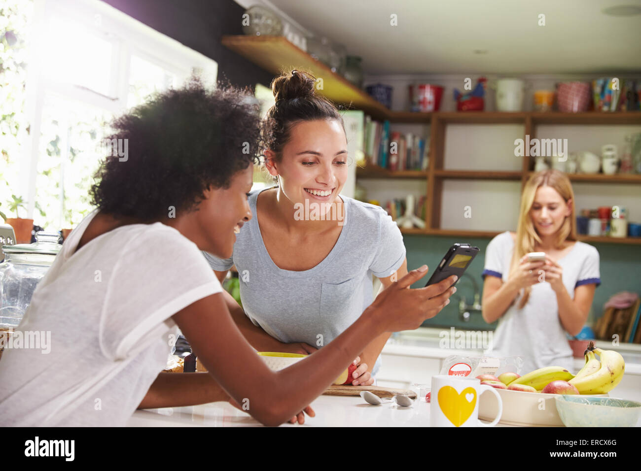 Female friends making breakfast whilst hi-res stock photography and ...
