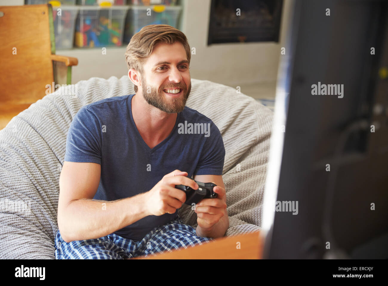 Man Wearing Pajamas Sitting In Chair And Playing Video Game Stock Photo ...