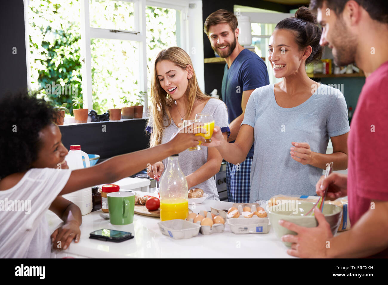 Group Of Friends Cooking Breakfast In Kitchen Together Stock Photo - Alamy
