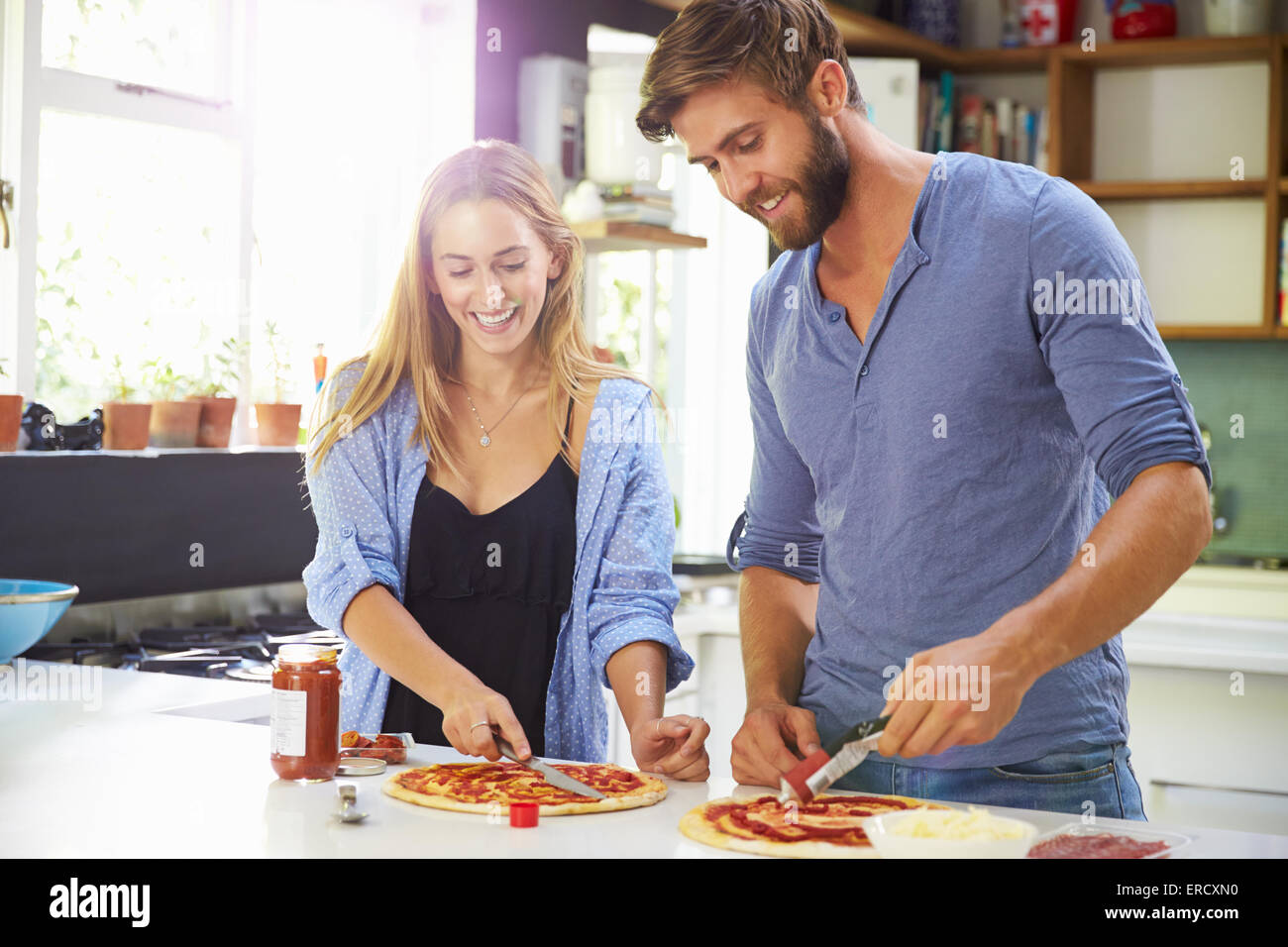 Young Couple Making Pizza In Kitchen Together Stock Photo - Alamy