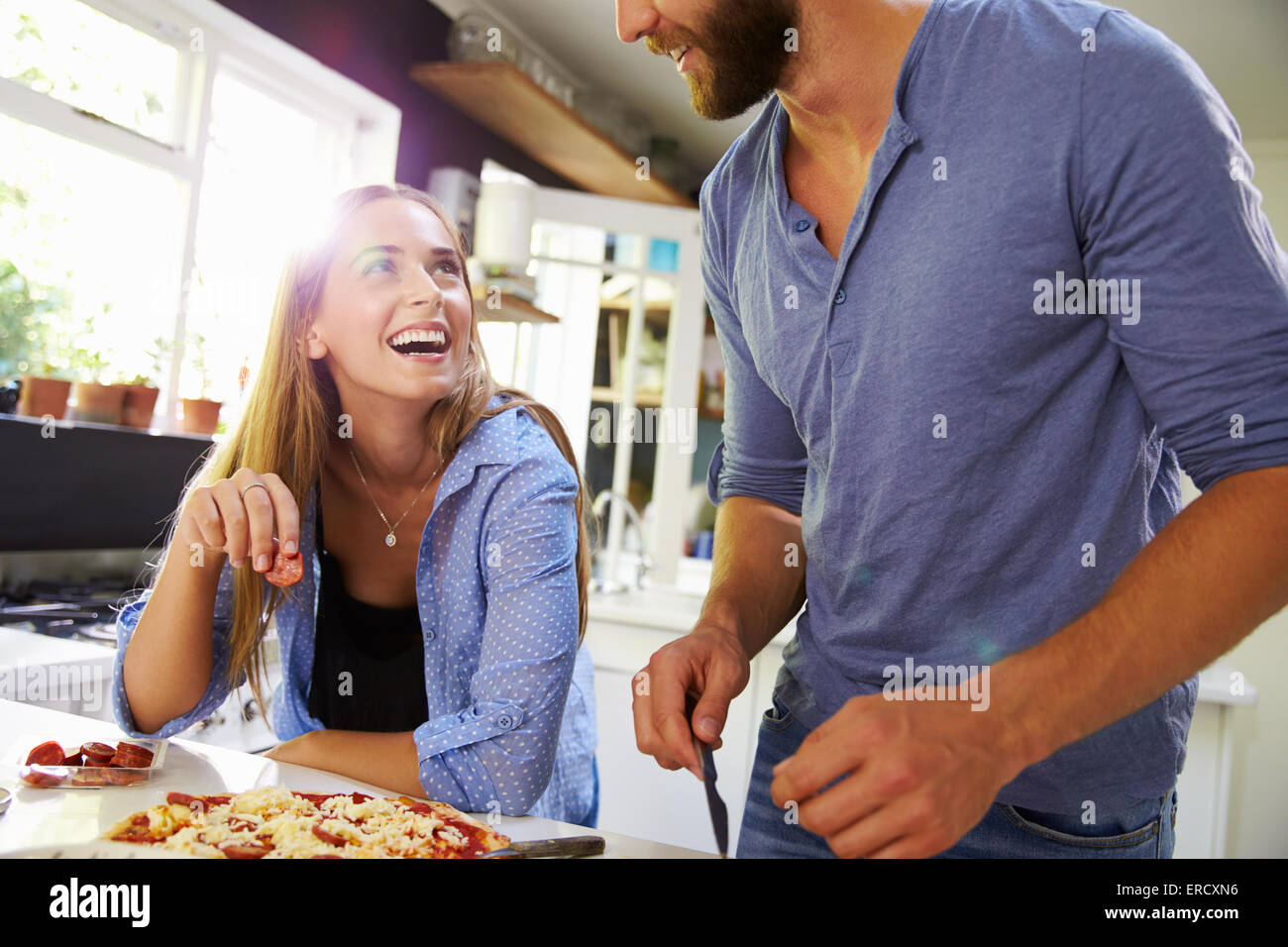 Young Couple Making Pizza In Kitchen Together Stock Photo - Alamy