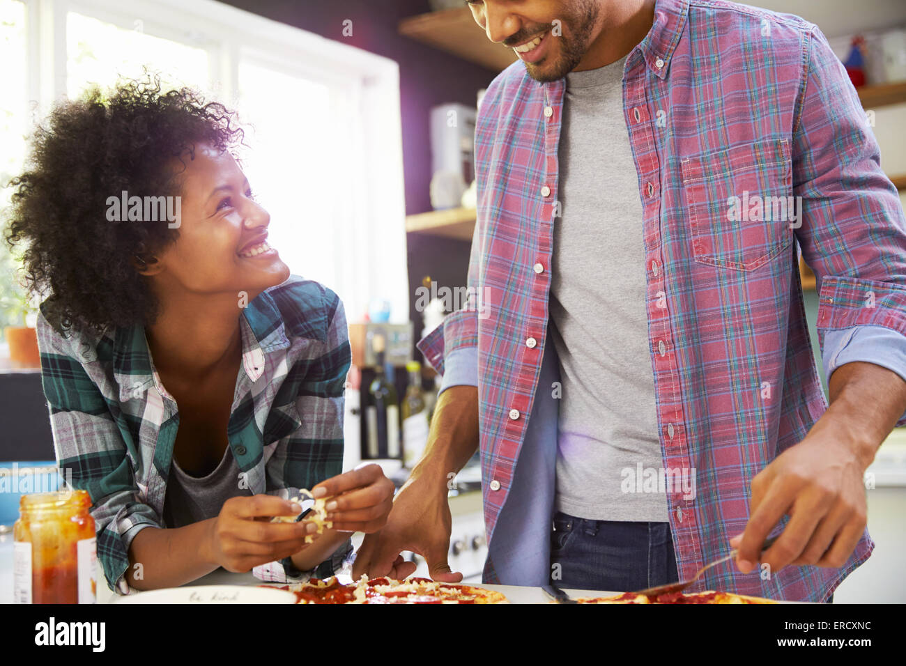 Young Couple Making Pizza In Kitchen Together Stock Photo - Alamy