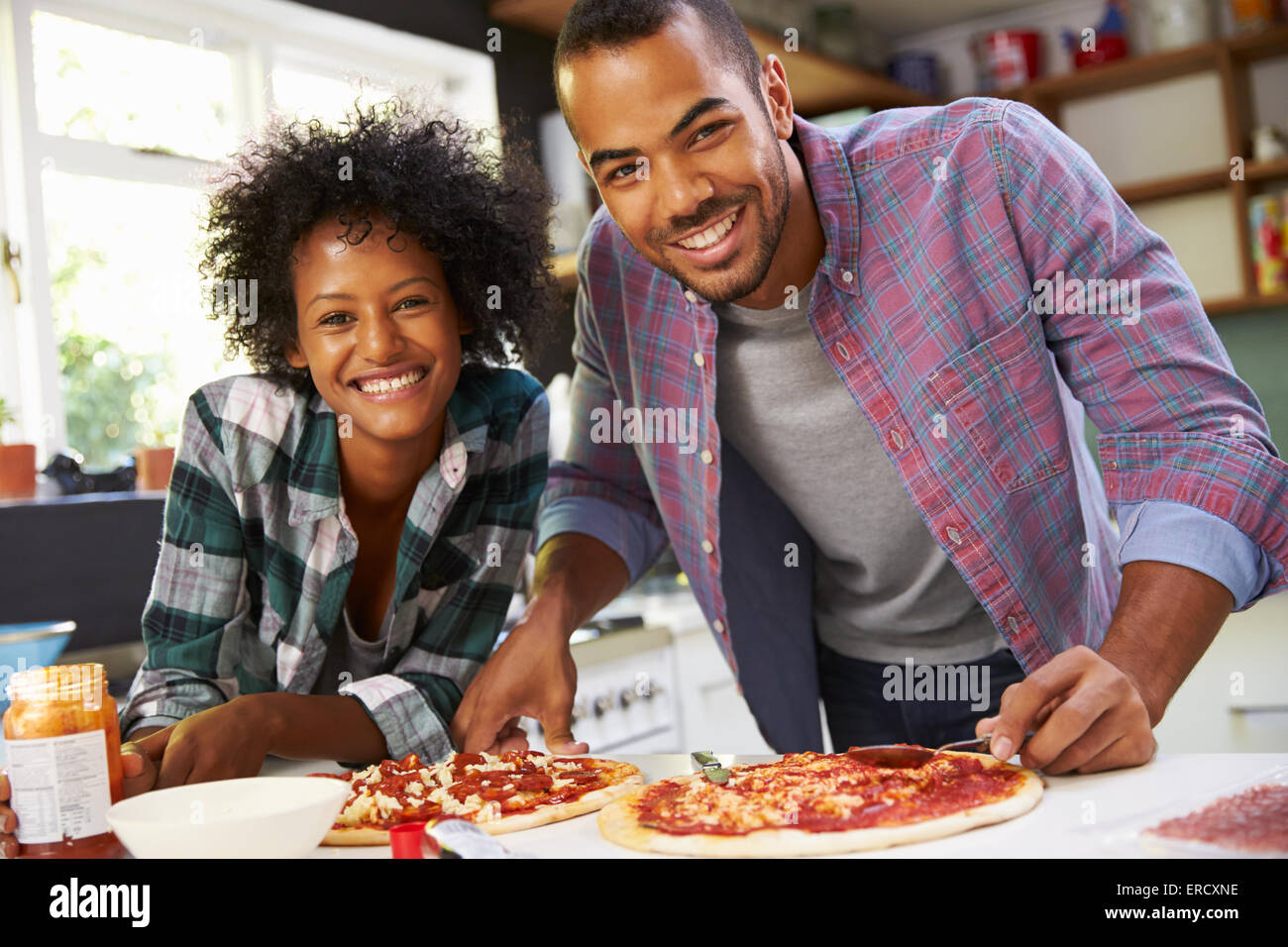 Young Couple Making Pizza In Kitchen Together Stock Photo - Alamy