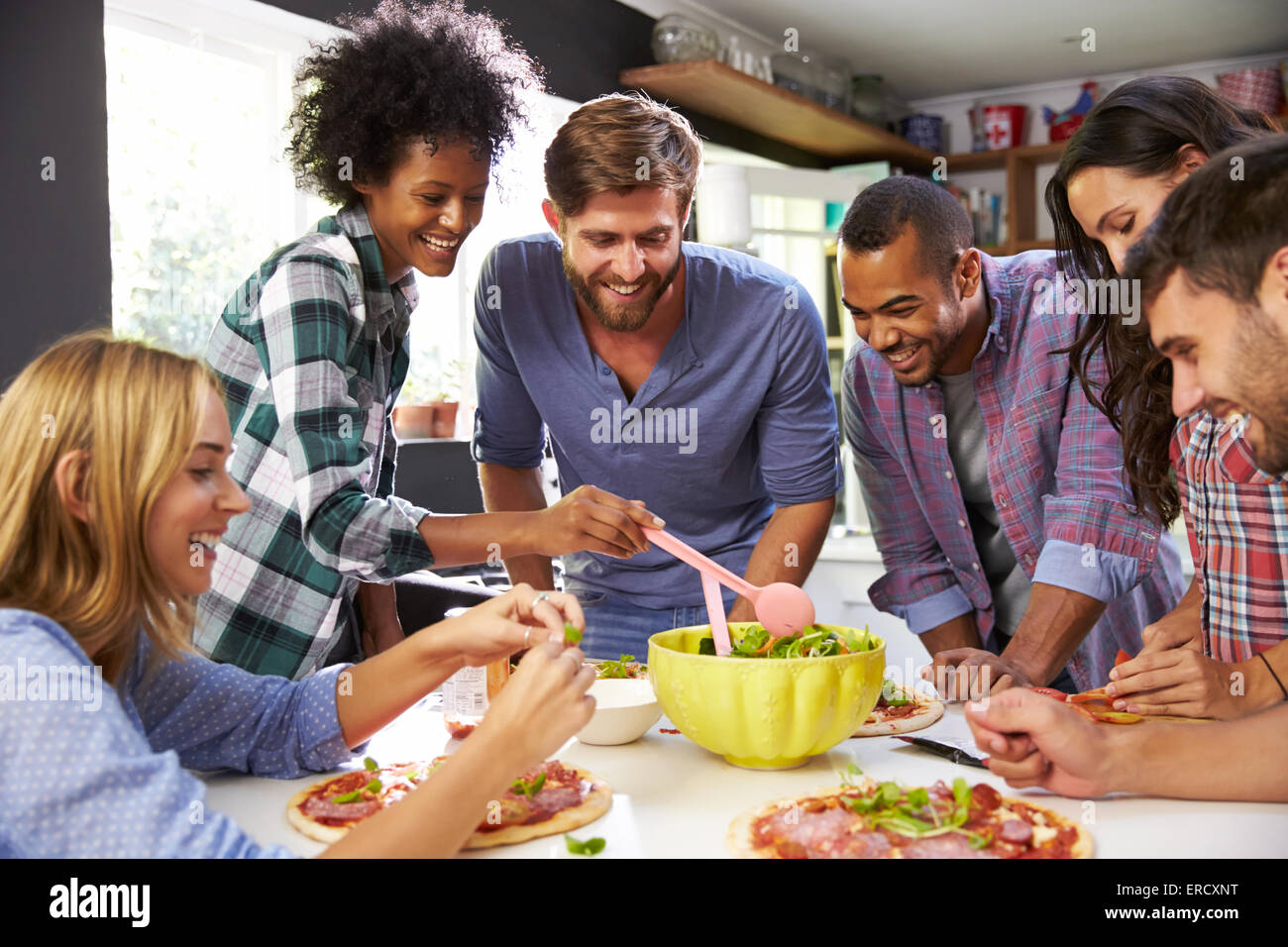 Group Of Friends Making Pizza In Kitchen Together Stock Photo - Alamy