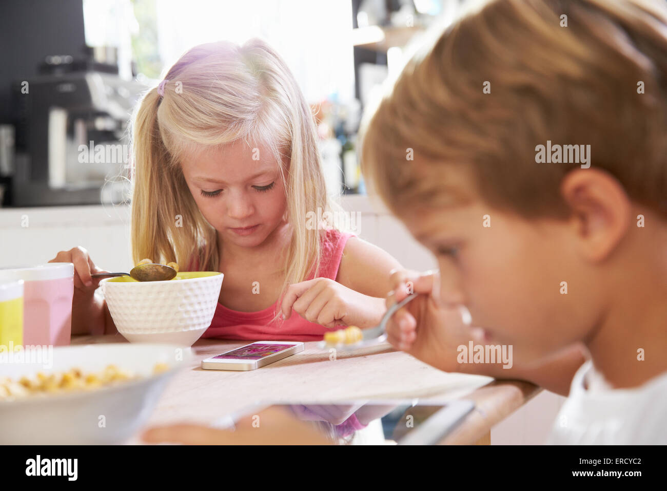 Brother sister eating breakfast texting hi-res stock photography and ...