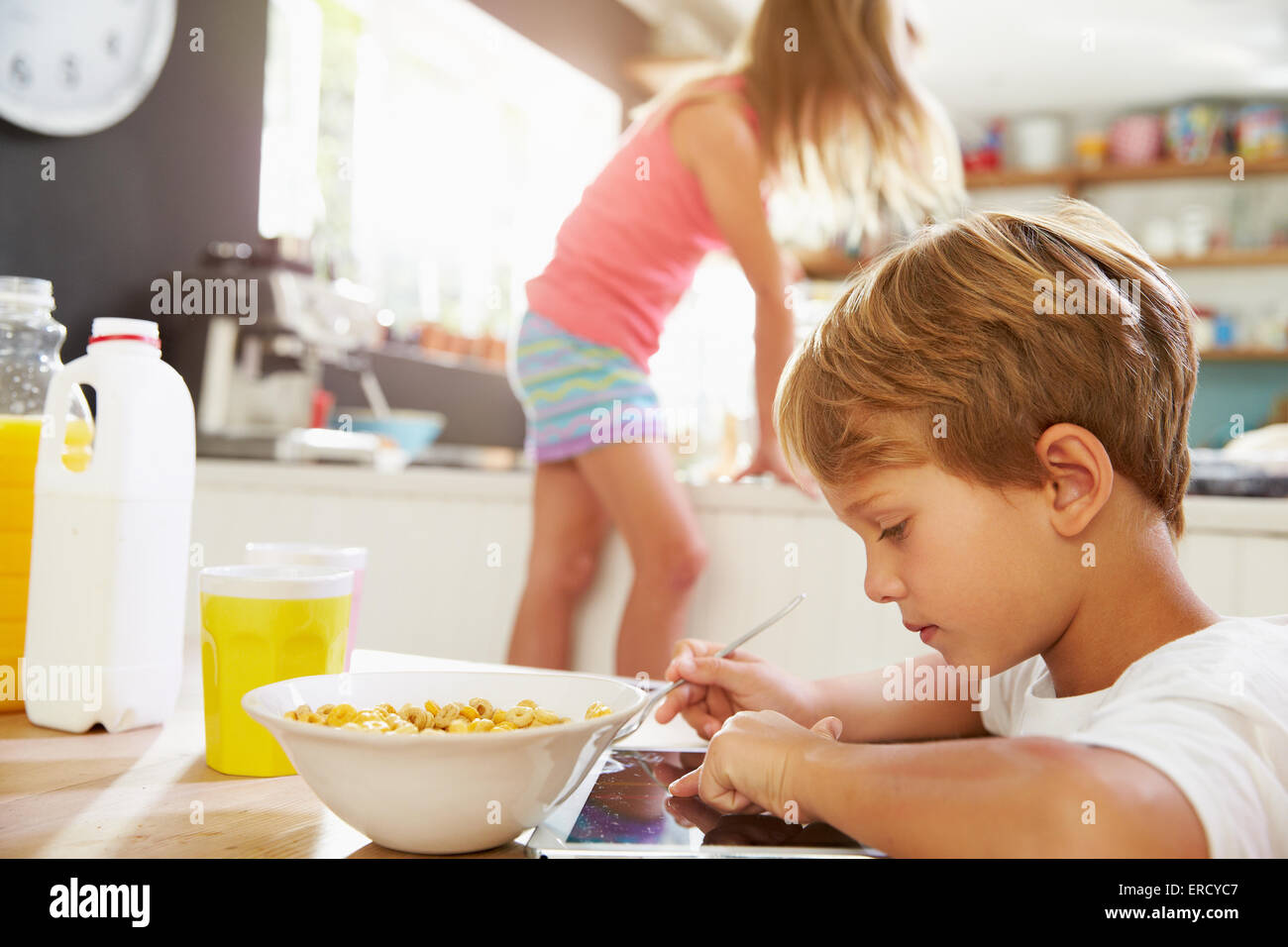 Children Eating Breakfast And Playing With Digital Tablet Stock Photo ...