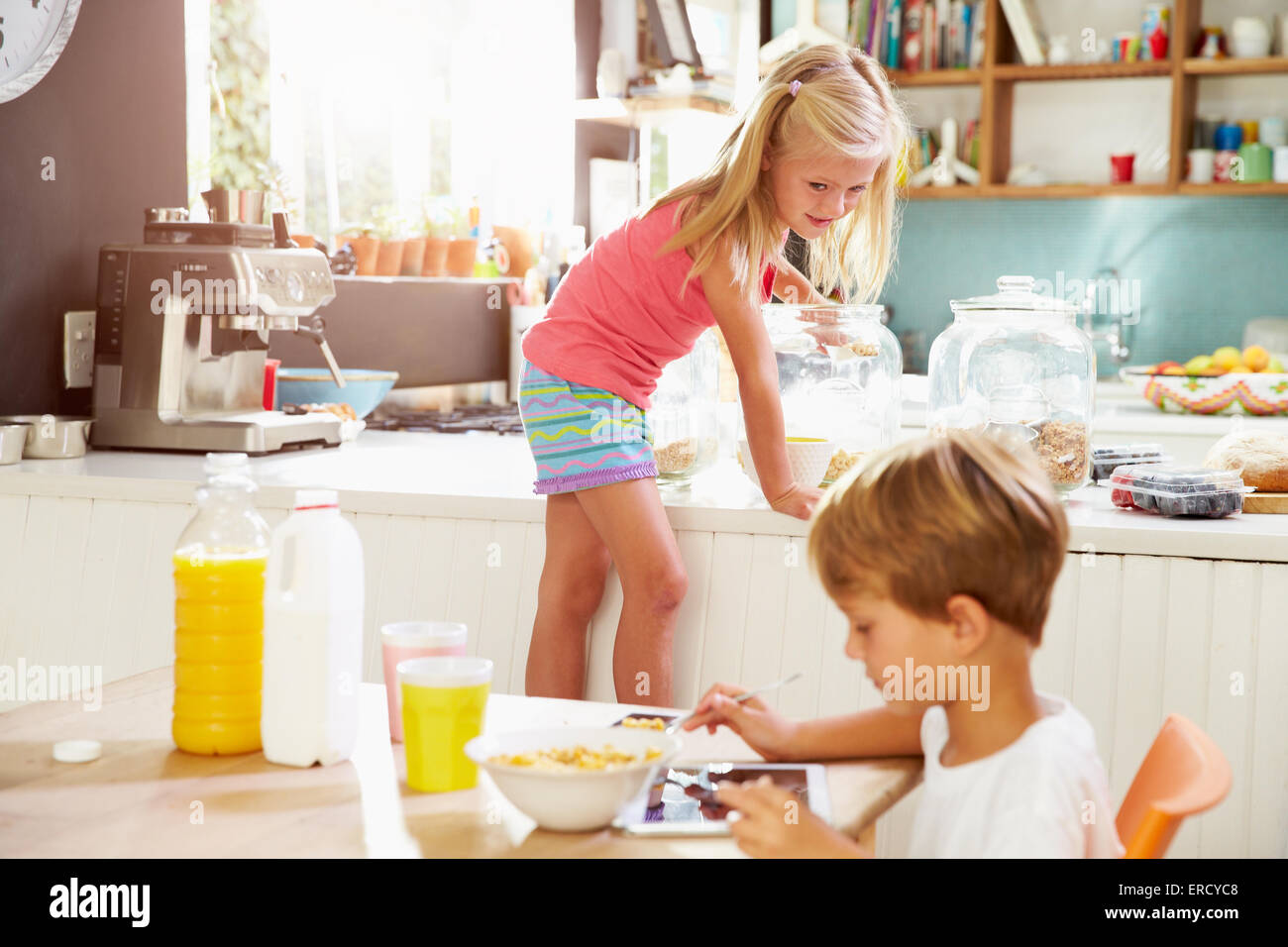 Children Eating Breakfast And Playing With Digital Tablet Stock Photo ...