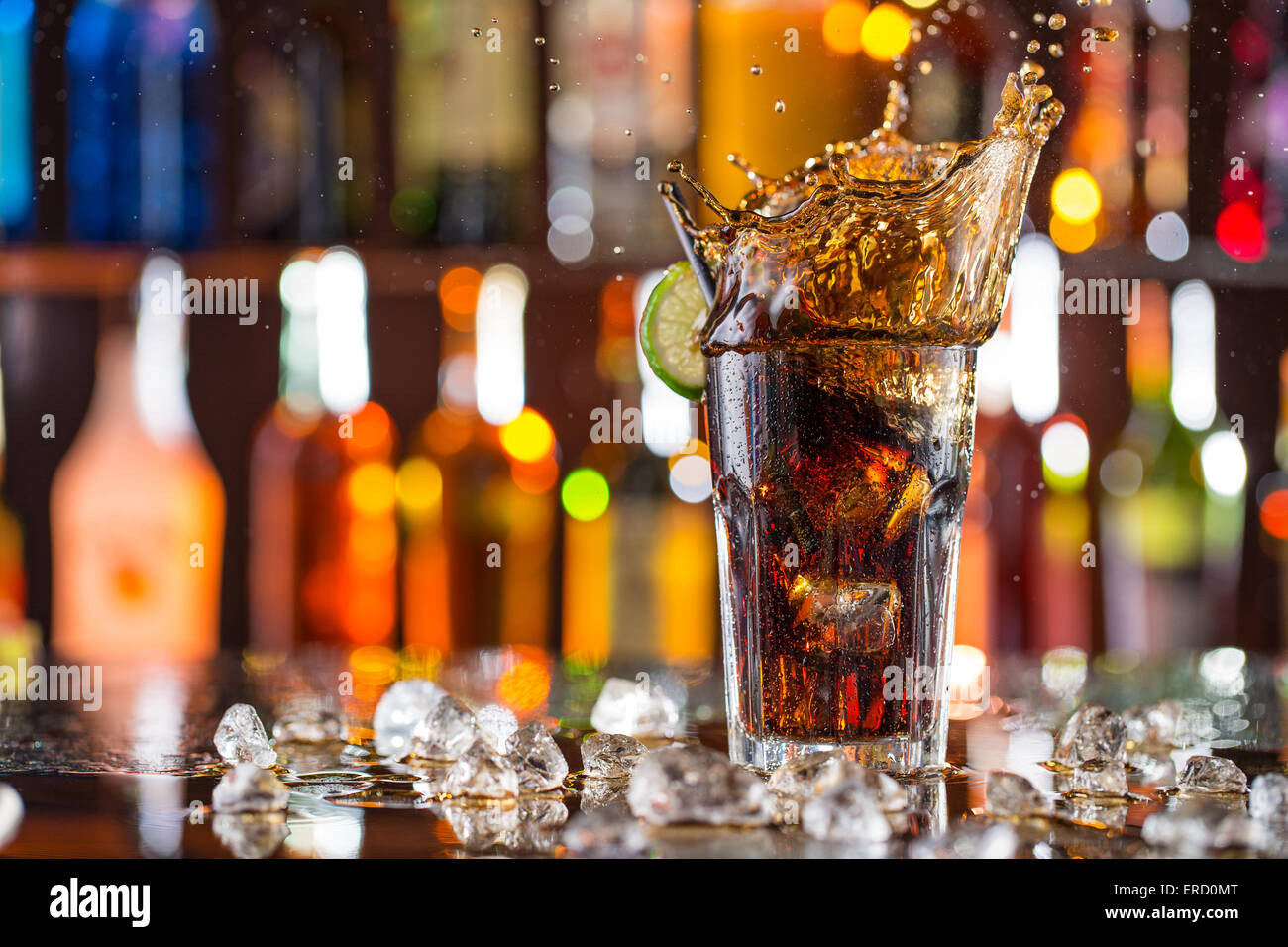 Glass of cola on bar desk with splashing liquid, close-up Stock Photo ...