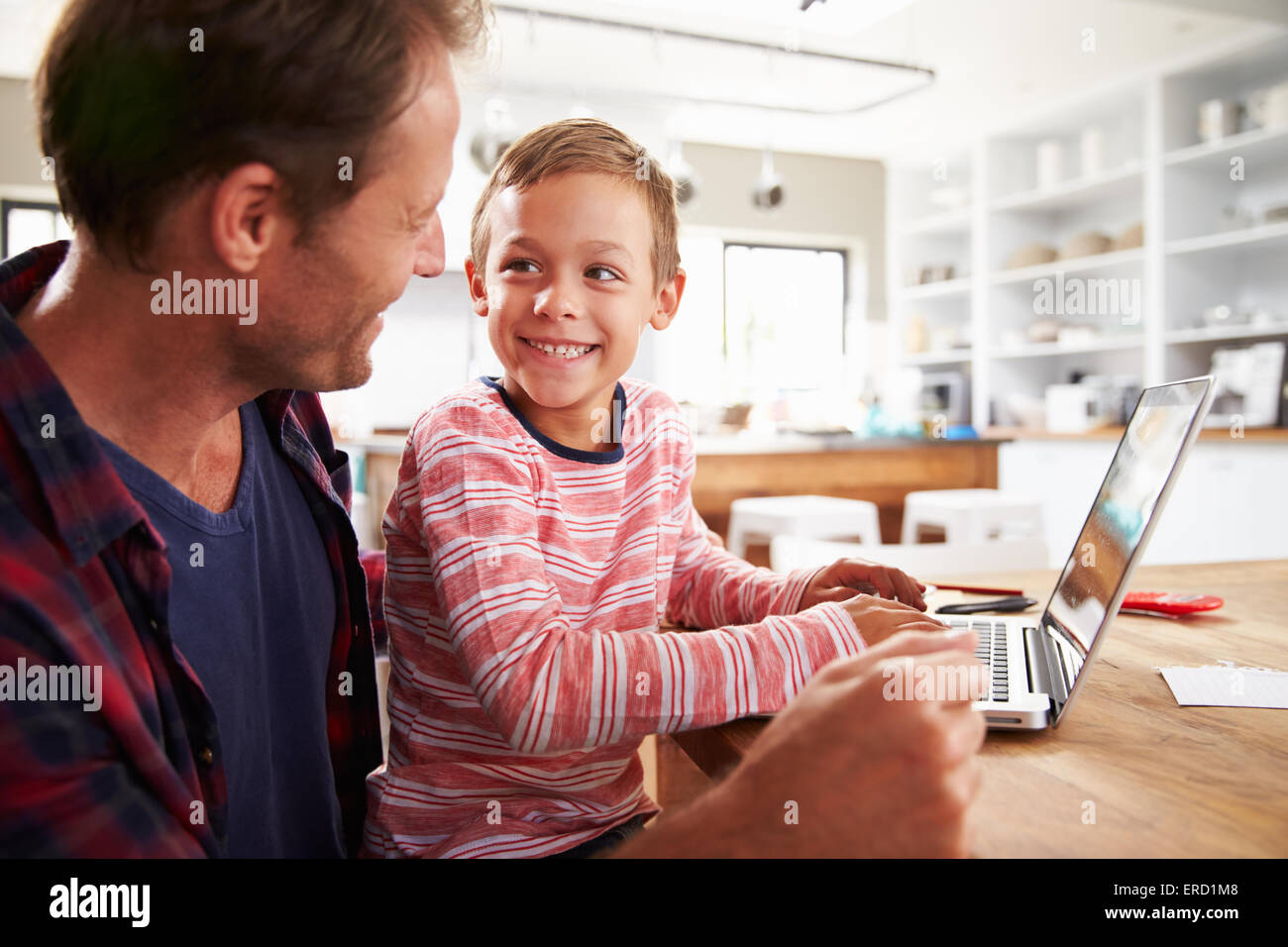 Father and son using laptop computer at home Stock Photo - Alamy