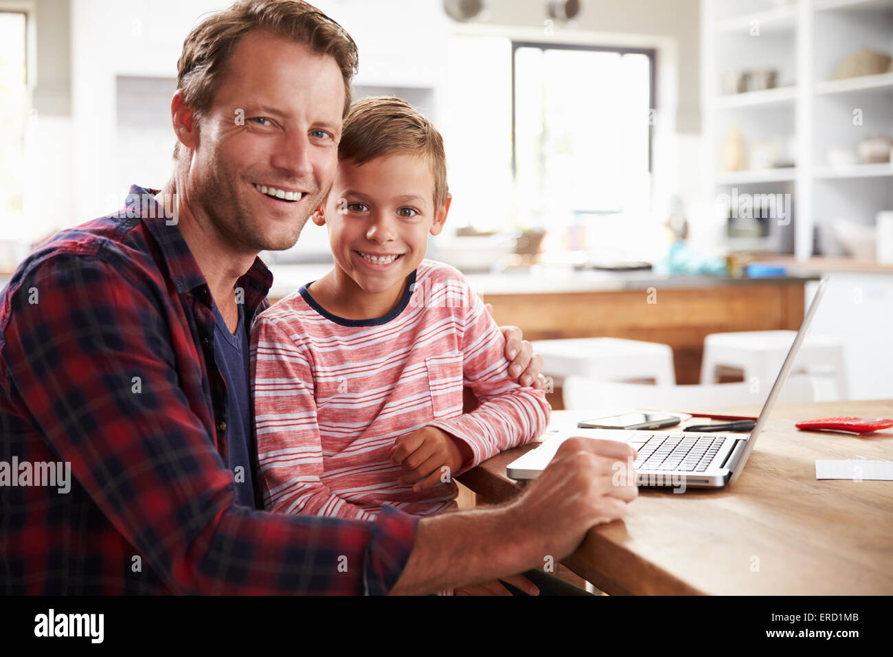 Father and son using laptop computer at home Stock Photo - Alamy