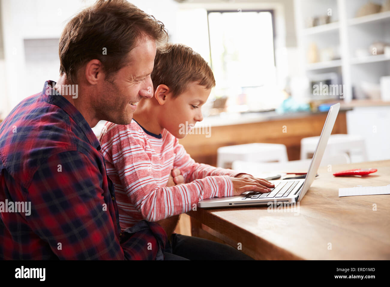Father and son using laptop computer at home Stock Photo - Alamy