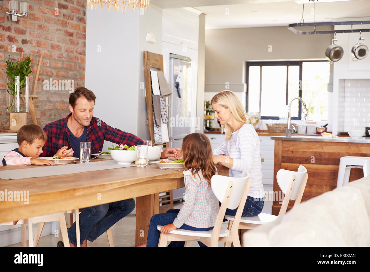 Family saying grace before dinner Stock Photo - Alamy