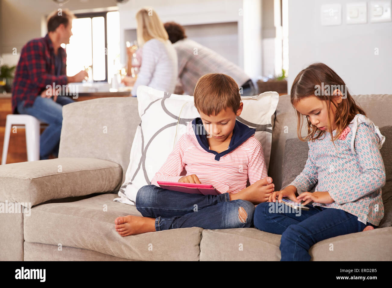 Kids playing with new technology while adults entertain Stock Photo - Alamy