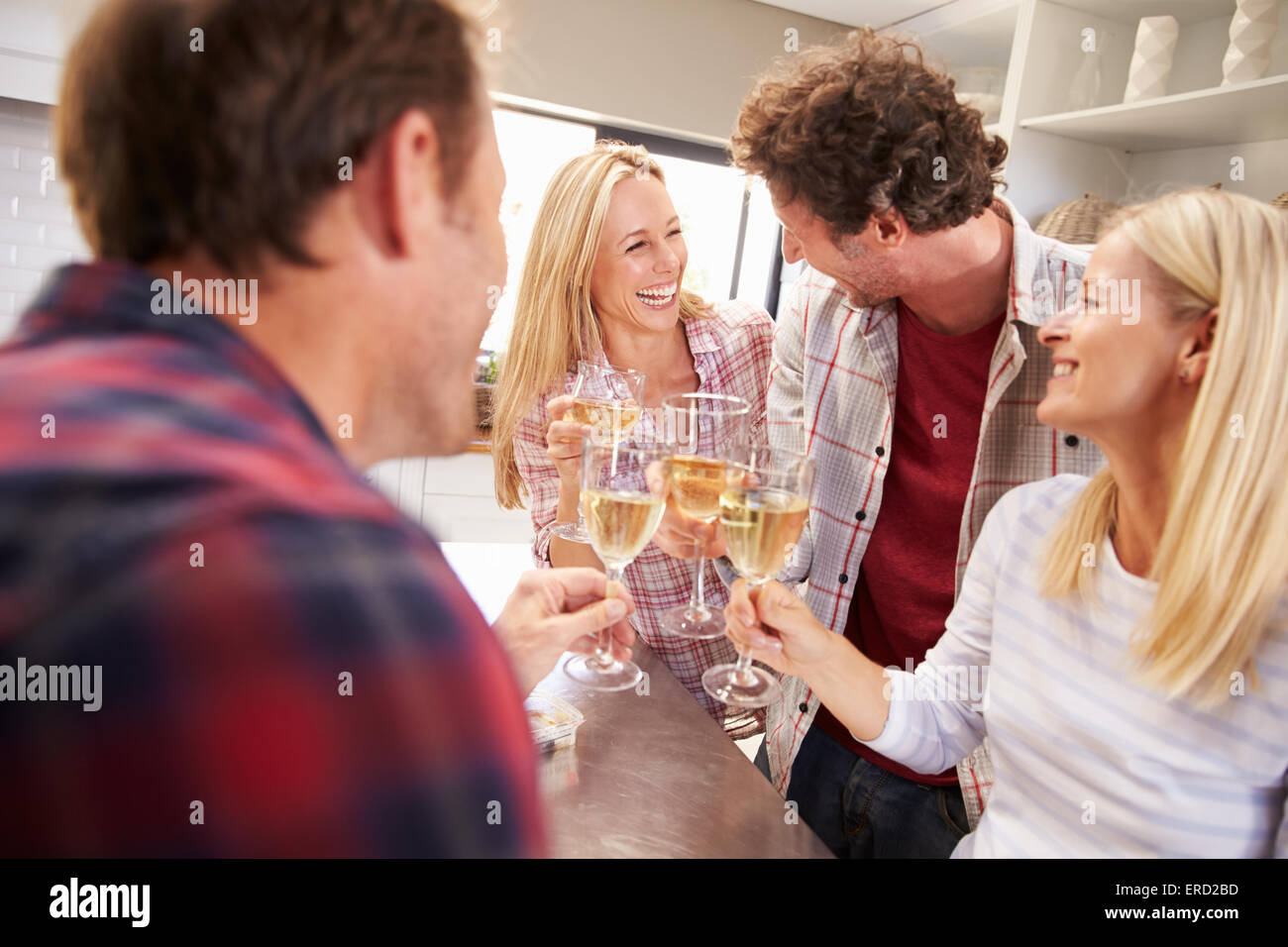 Four friends celebrating at home Stock Photo - Alamy