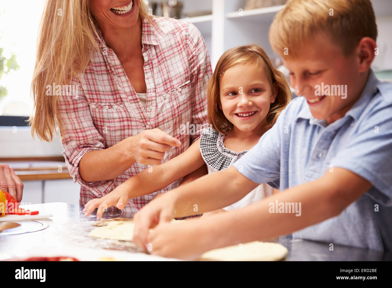 Mother preparing pizza with kids Stock Photo - Alamy