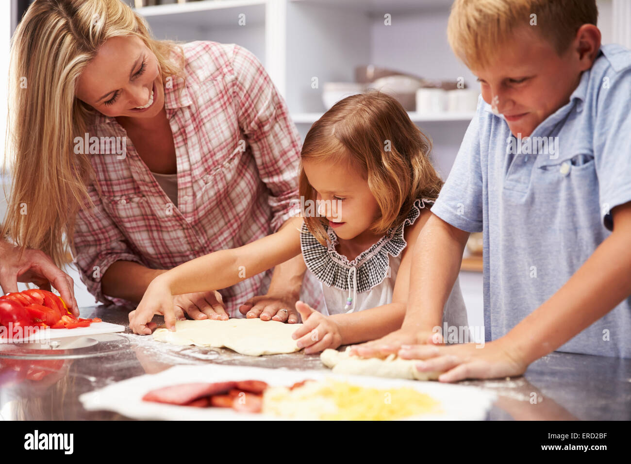 Mother preparing pizza with kids Stock Photo - Alamy