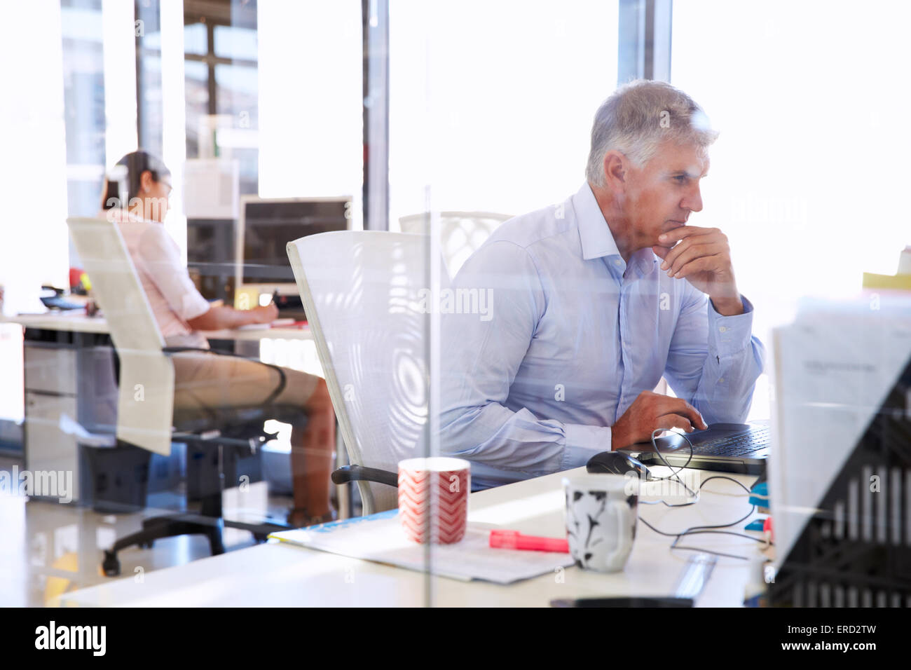 Man working at a computer, office interior Stock Photo - Alamy