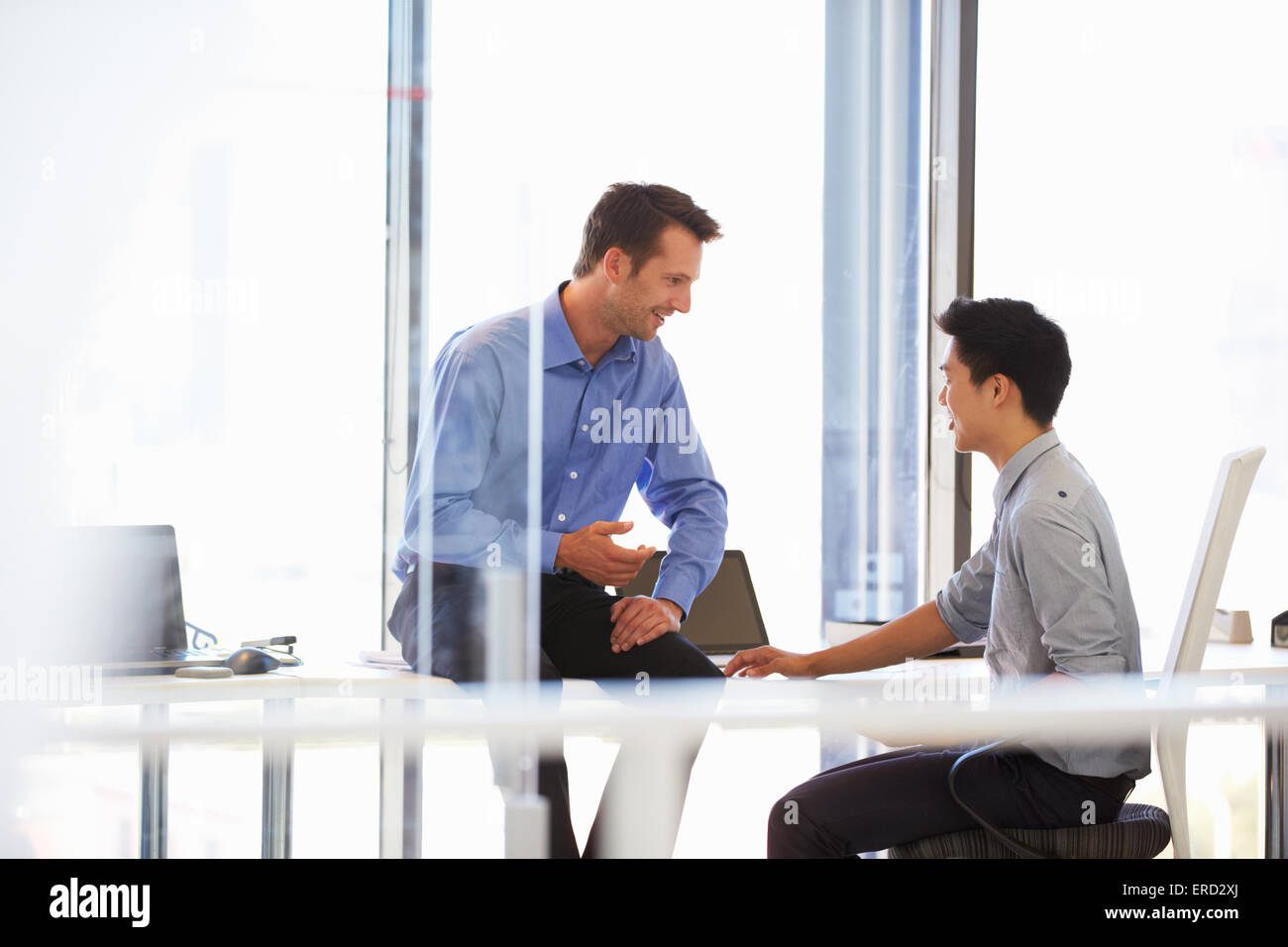 Two men talking in a modern office Stock Photo - Alamy