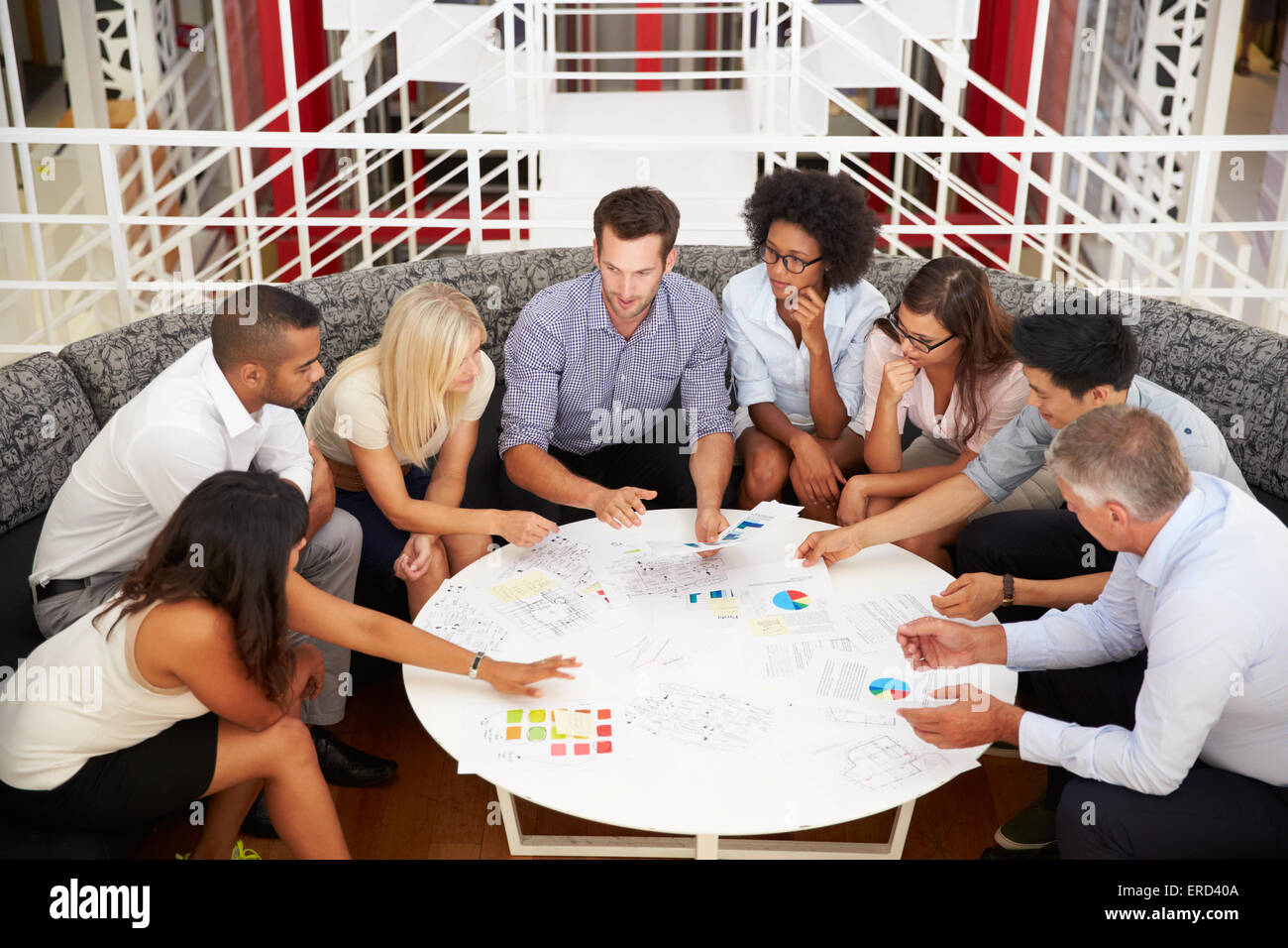 Group of work colleagues having meeting in an office lobby Stock Photo ...