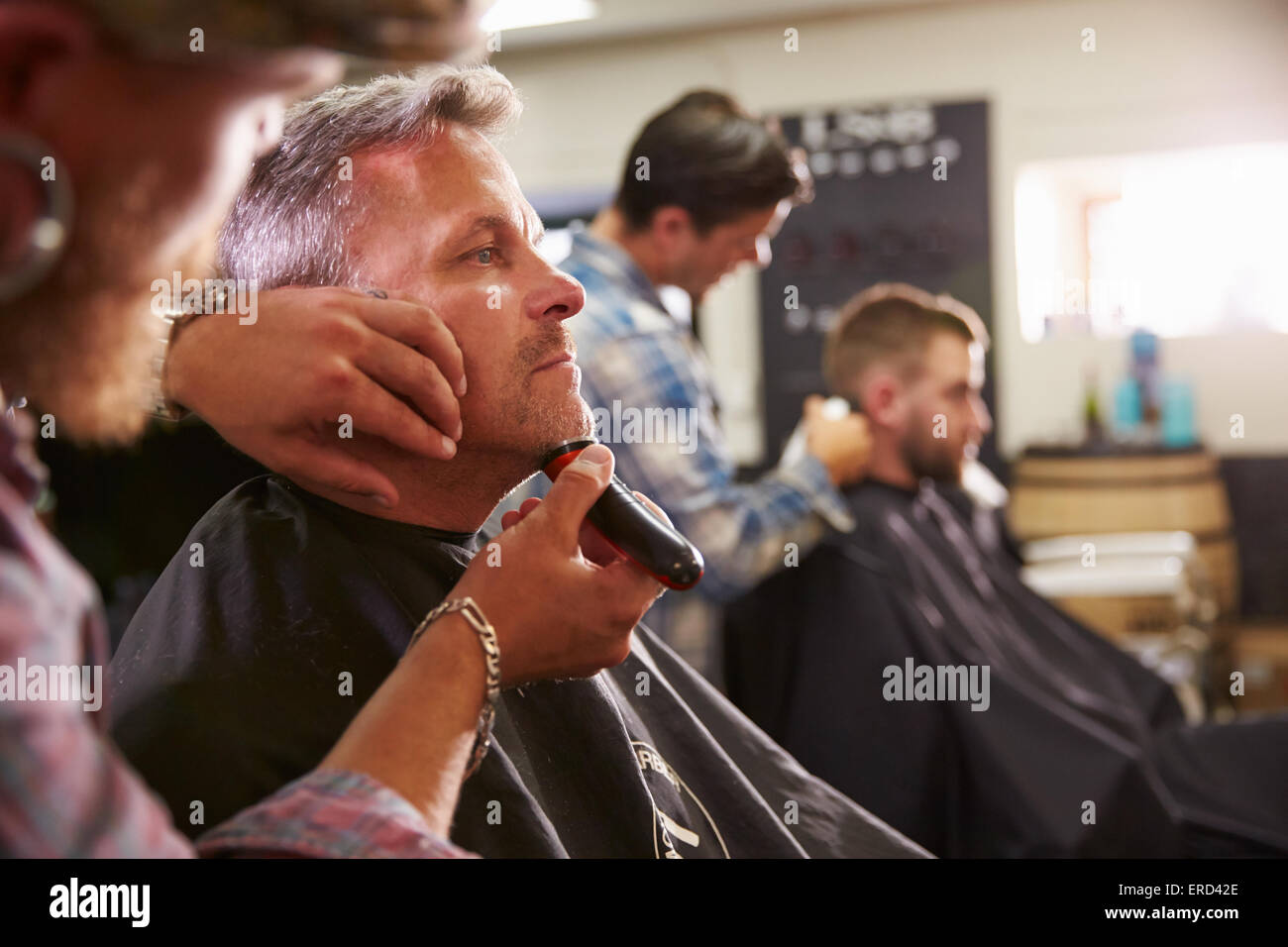 Male Barber Giving Client Shave In Shop Stock Photo - Alamy