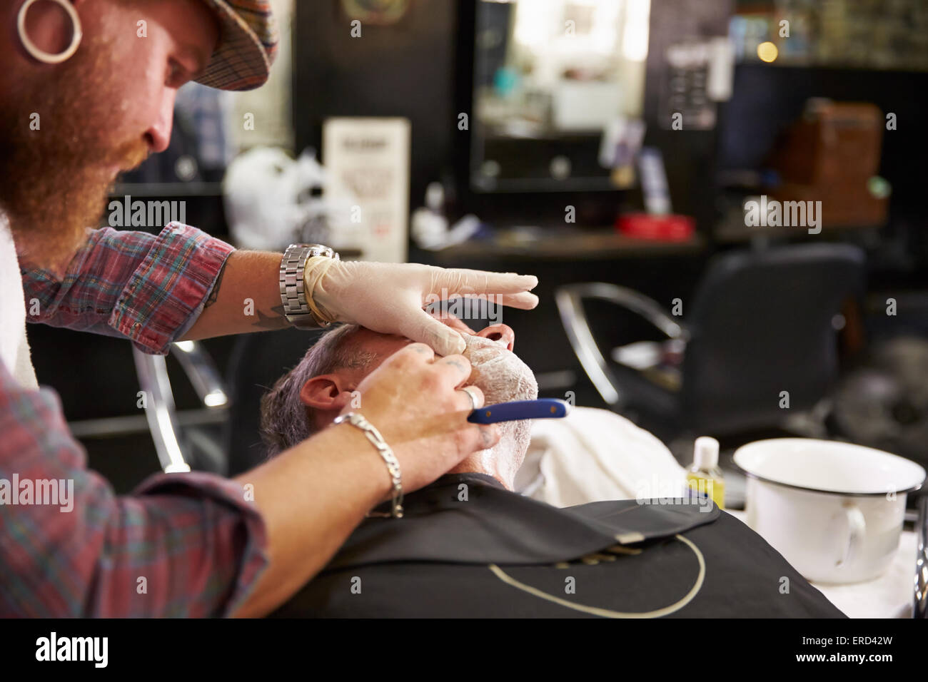 Barber Shaving Client With Cut Throat Razor Stock Photo - Alamy