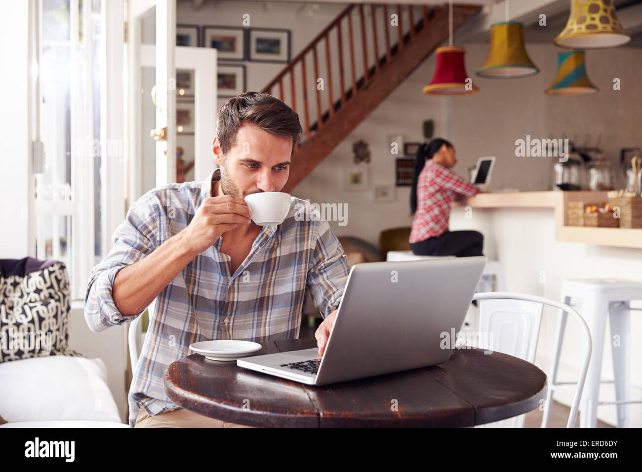 Young man using laptop in a cafe Stock Photo - Alamy