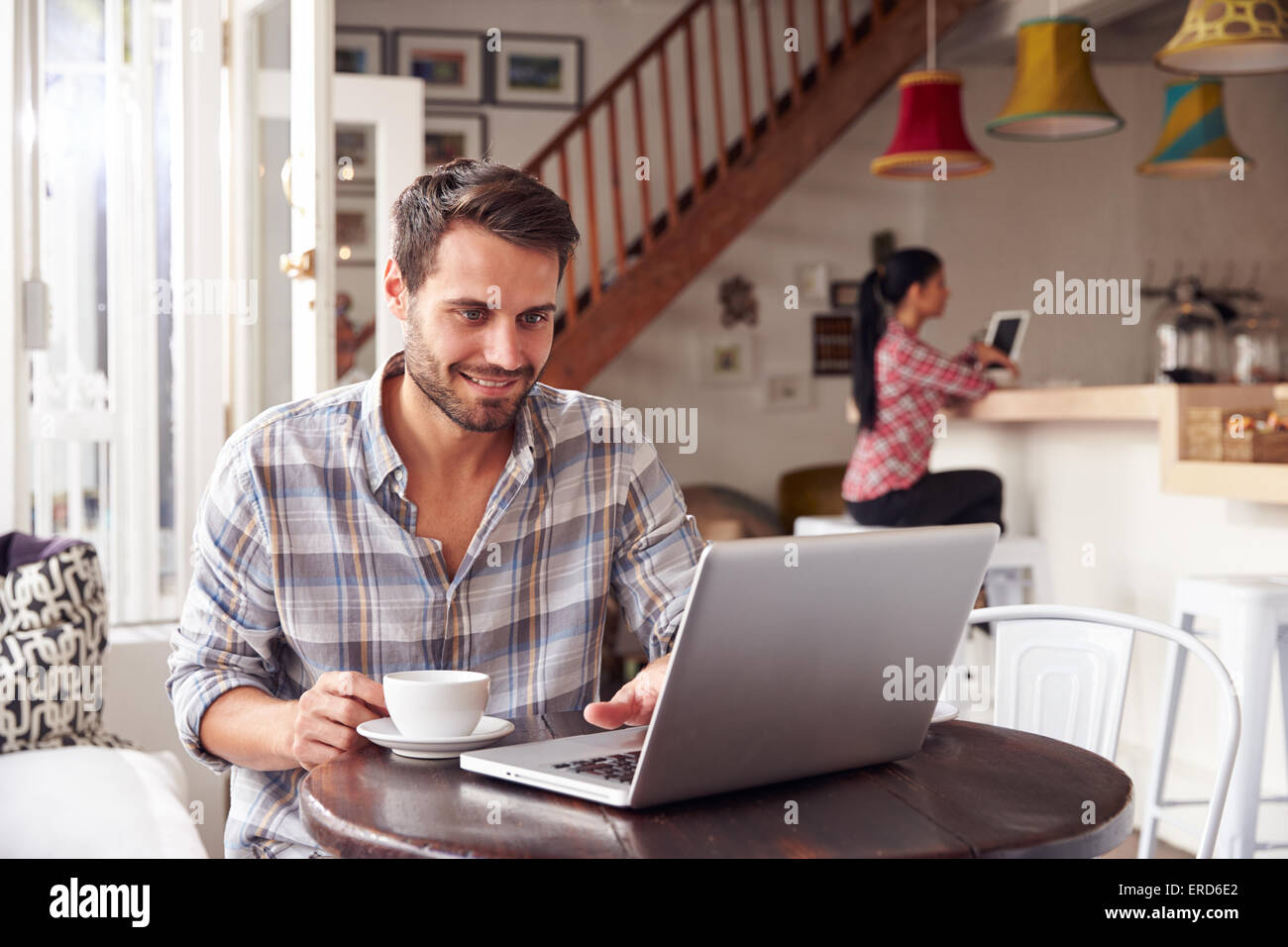 Young man using laptop in a cafe Stock Photo - Alamy