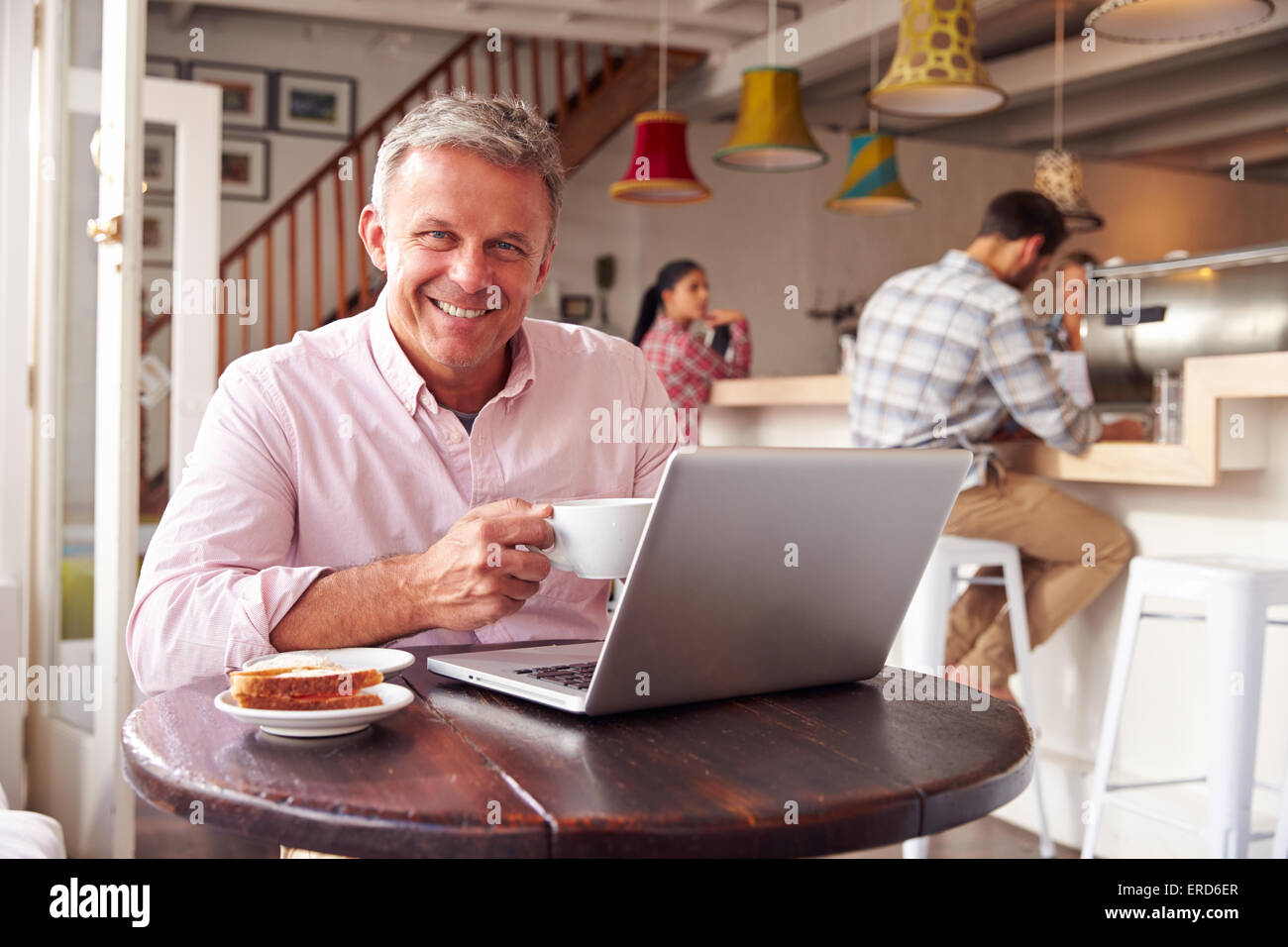 Middle aged man working in a cafe Stock Photo - Alamy
