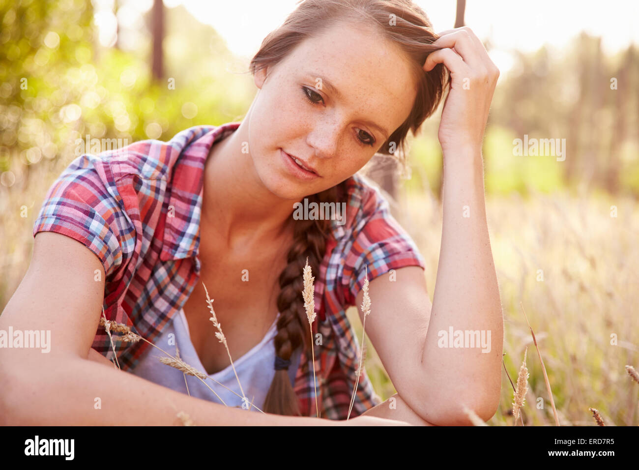 Portrait Of Woman Sitting In Countryside In Field Of Grass Stock Photo ...
