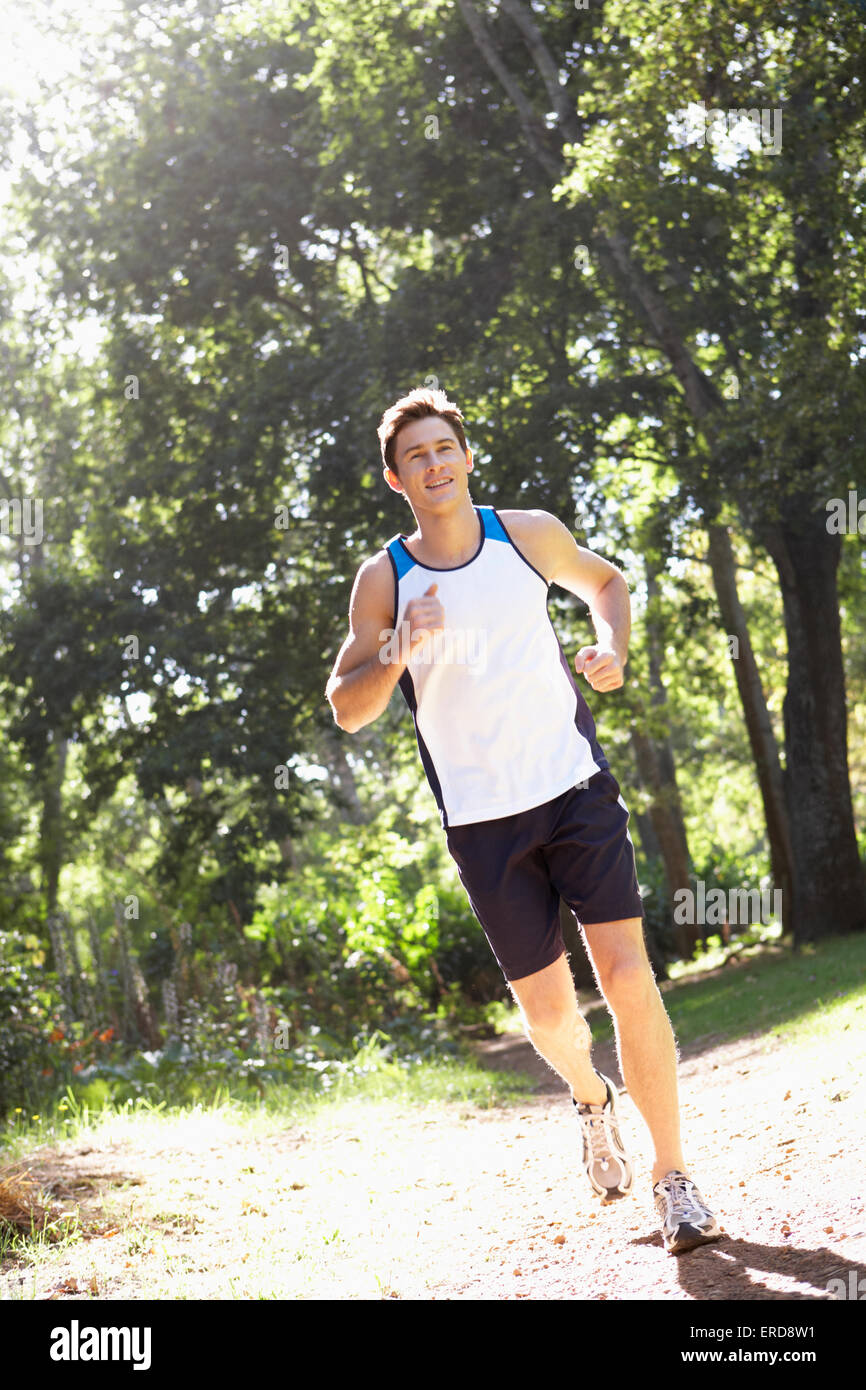 Young Man Running Along Woodland Path Stock Photo - Alamy